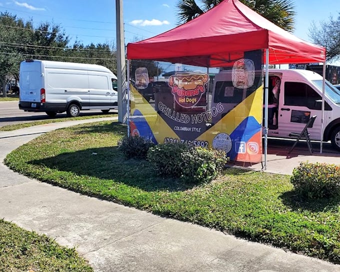 Colombian-style hot dog magic happens under this unassuming red tent &ndash; proof that culinary treasures often hide in plain sight.