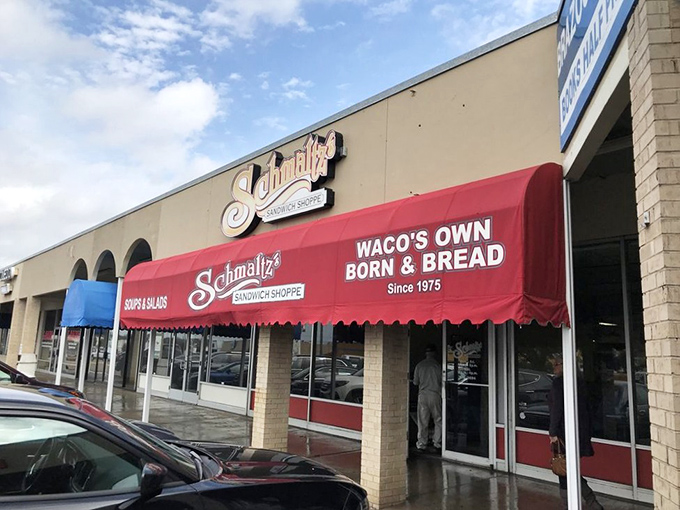 Schmaltz's red awning beckons like a lighthouse for sandwich lovers navigating Waco's culinary landscape perfectly.