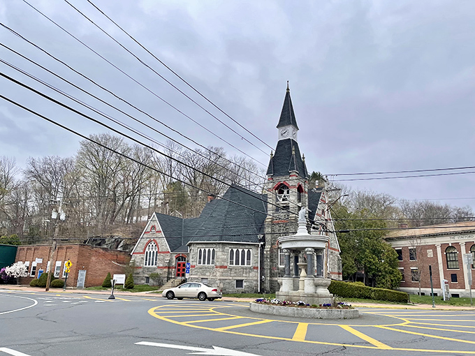 A historic stone church with a striking steeple stands proudly in Stafford Springs, showcasing the town's classic New England character.
