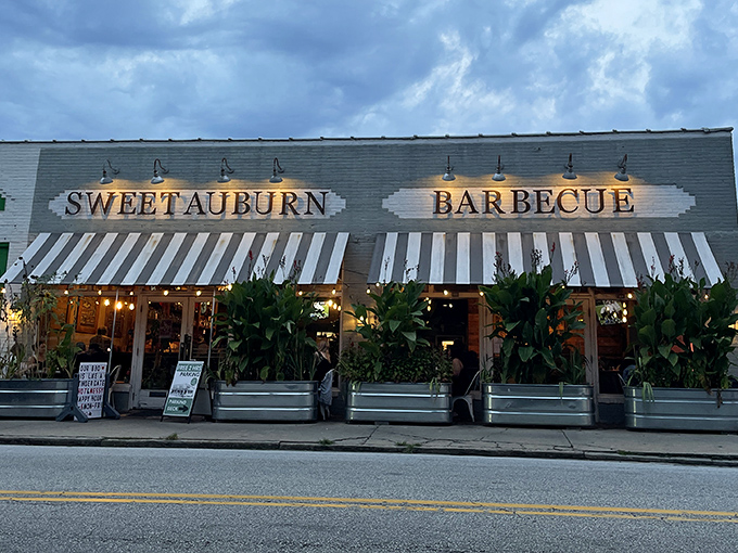 String lights and striped awnings create the perfect atmosphere for savoring barbecue that bridges Southern tradition with modern flair.