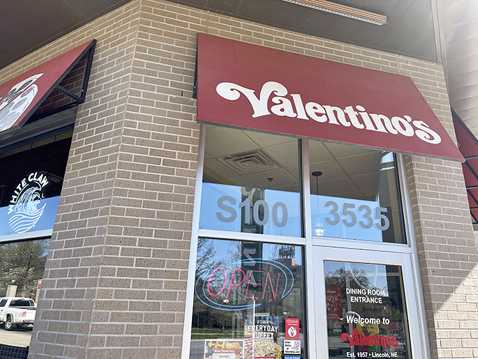 The familiar red awning signals comfort food ahead, where Nebraska pizza traditions live on strong.