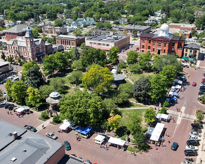 The heart of Woodstock features an aerial view of its central park surrounded by historic buildings and tree-lined streets.