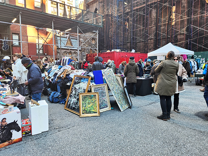 Framed art leans casually against boxes in this outdoor gallery where masterpieces hide among the everyday finds.