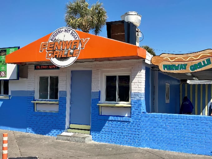 The bright orange awning of Fenway Grille beckons beach-goers to trade saltwater for savory dogs with a New England accent.