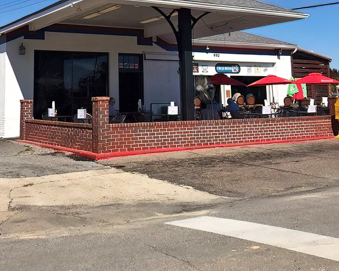 That brick patio says "stay awhile" while the red umbrellas promise shade for your seafood feast.