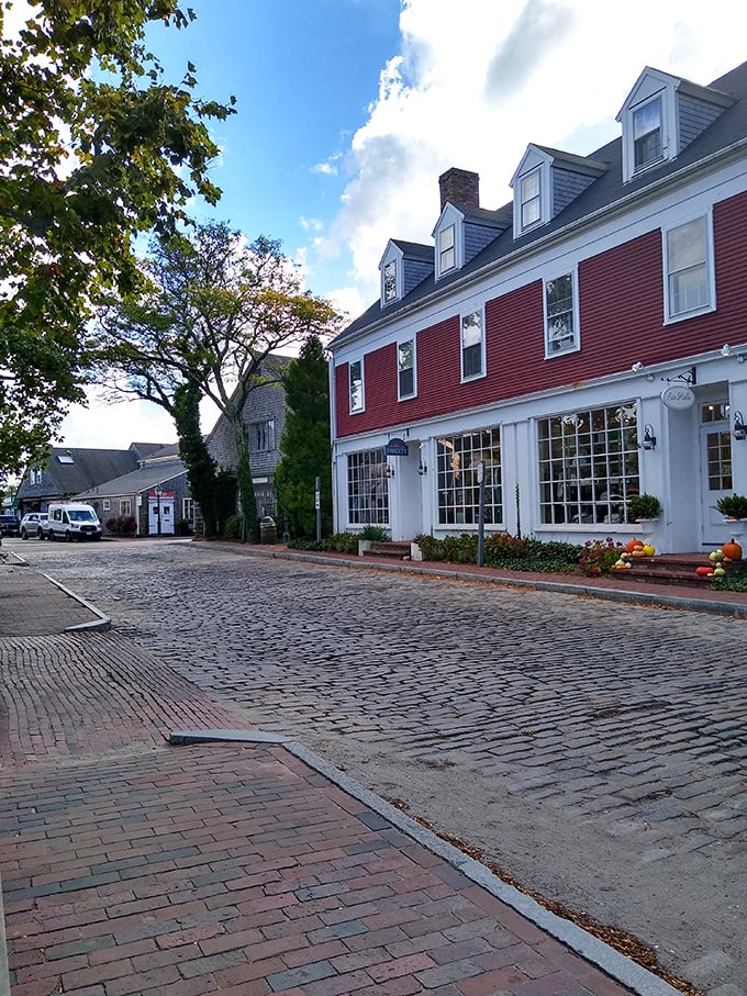 This red-shuttered beauty stands like a proud sentinel, watching over island life with timeless New England grace.