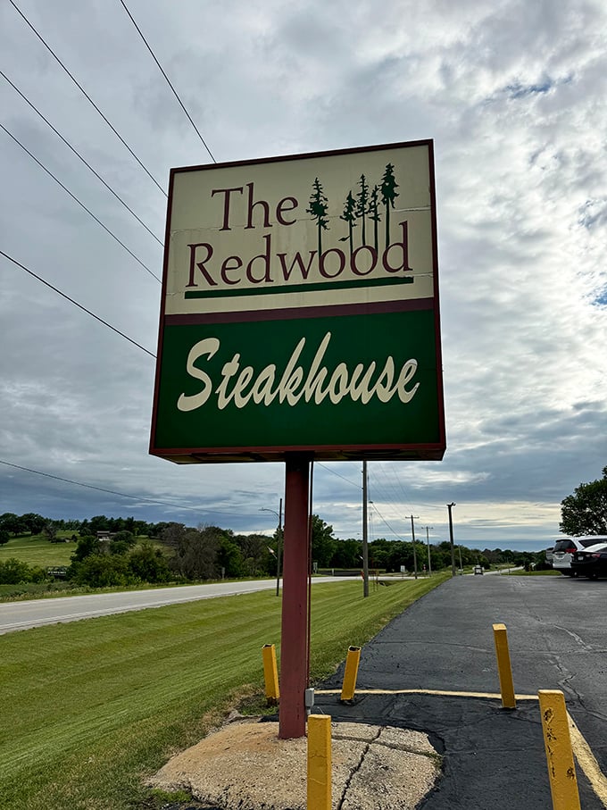 That classic Redwood sign stands tall against Iowa skies &ndash; promising steaks worth the drive and a salad bar that's actually worth visiting.