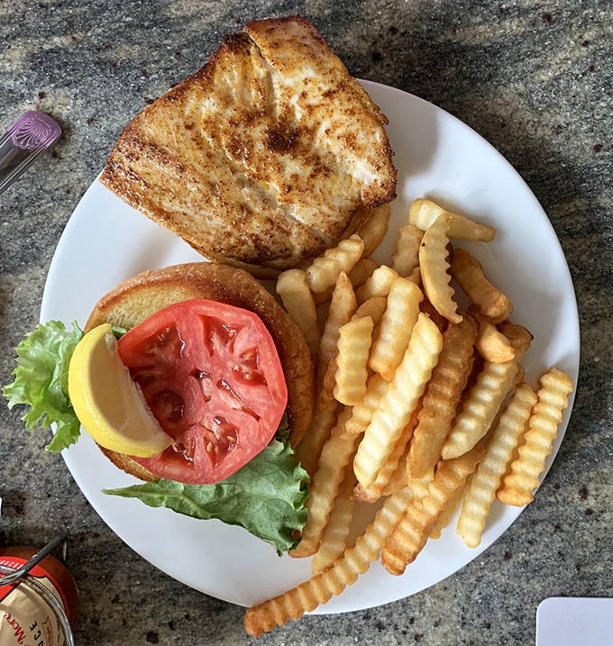 The fish sandwich that launched a thousand road trips. Golden-crusted catch nestled between a toasted bun with crispy fries—simplicity that speaks volumes.