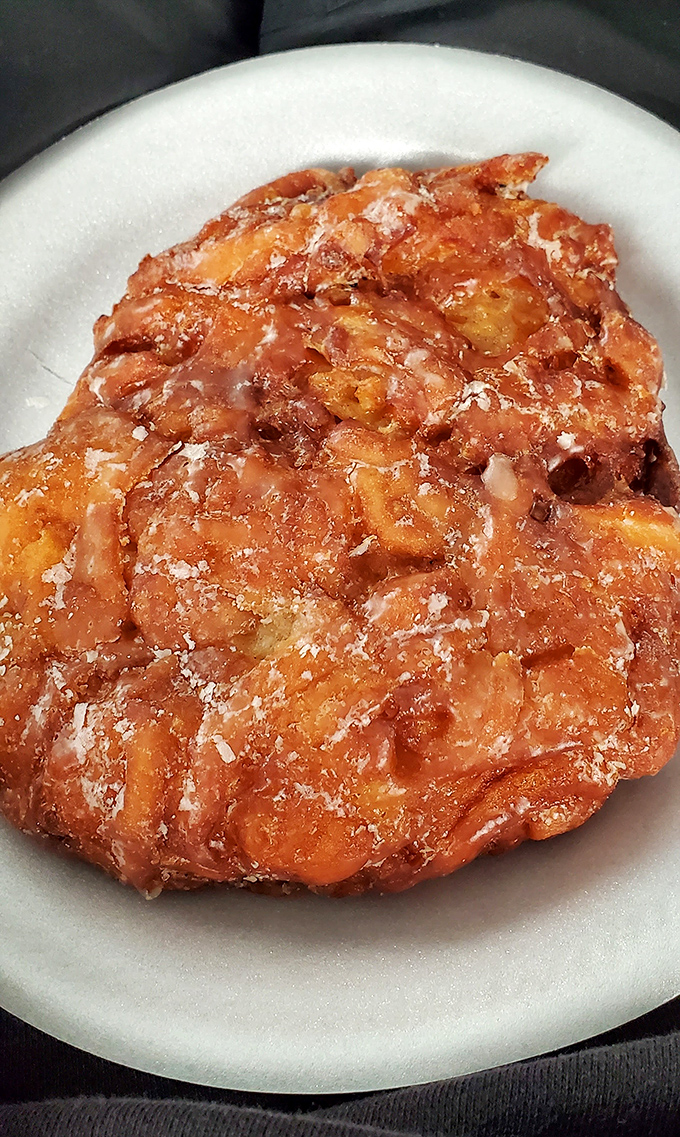 This apple fritter isn't just a donut—it's a craggy landscape of caramelized apples and cinnamon, dusted with powdered sugar like the first snow of winter.