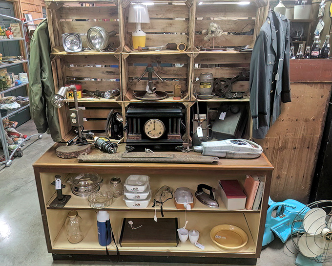 A vintage mantel clock stands sentinel among wooden crates and everyday artifacts that once powered American households through simpler times.
