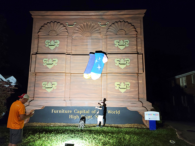 Even after dark, the World's Largest Chest of Drawers stands illuminated, a beacon for furniture enthusiasts and roadside attraction aficionados alike.