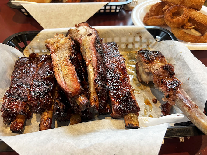 These ribs have that perfect mahogany bark – evidence of a patient pitmaster who understands the sacred relationship between meat, smoke, and time.