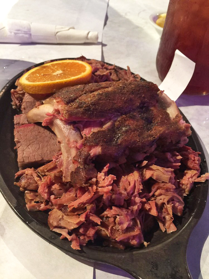 Baby back ribs with that perfect pink smoke ring and a bark so beautiful it deserves its own exhibition. The orange slice is just showing off.
