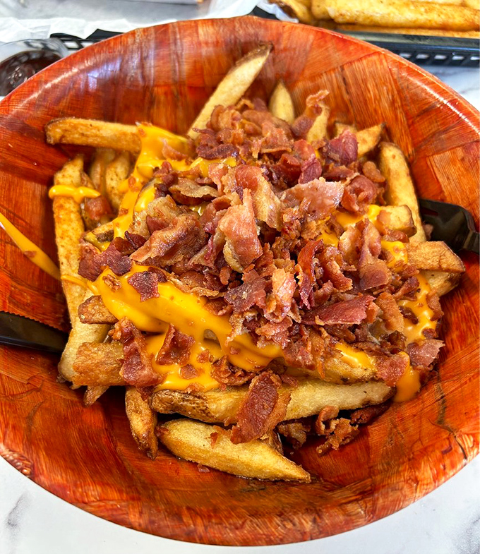 Bacon cheese fries served in a wooden bowl&mdash;because when you're going all in on indulgence, plastic just won't do. Diet starts tomorrow, folks!