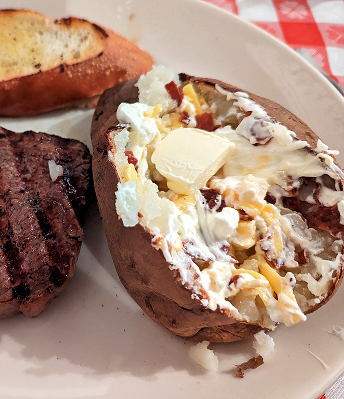 The loaded baked potato isn't a side dish&mdash;it's a co-star that deserves its own billing, complete with butter melting like a sunset.