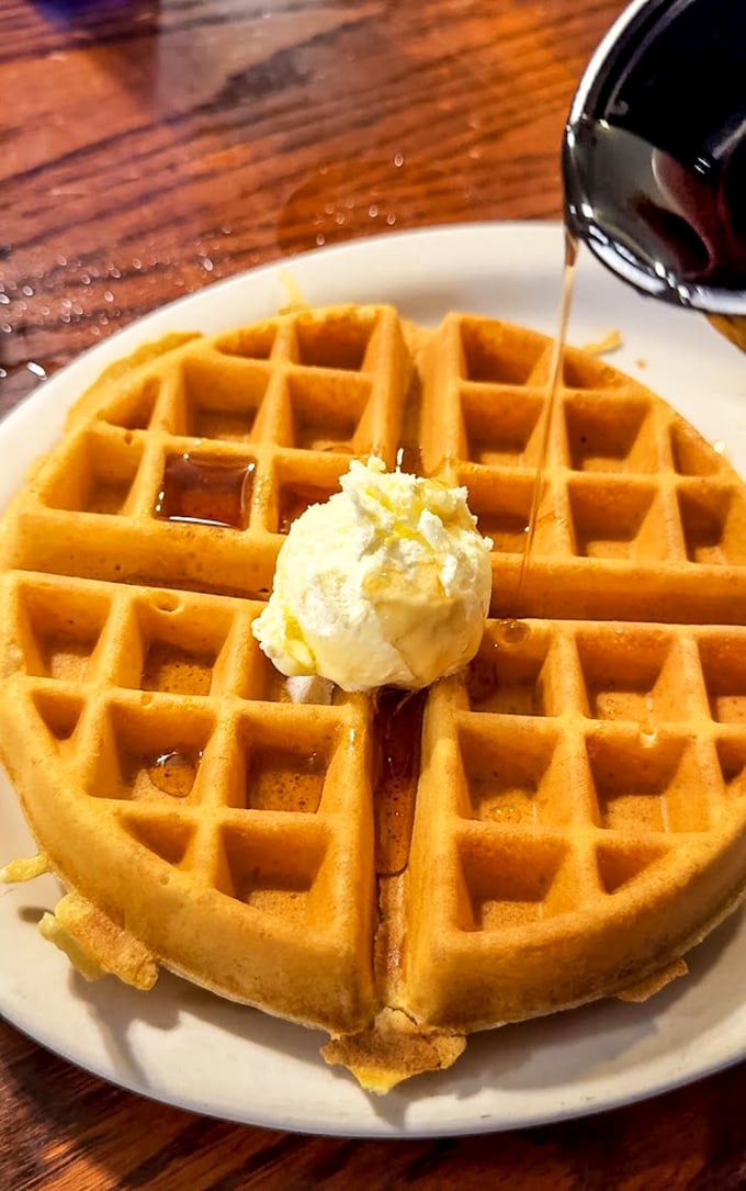 The Belgian waffle arrives like a golden canvas, butter melting into each perfect square, maple syrup poised to create a breakfast masterpiece.