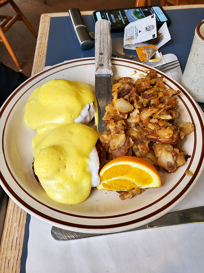 Eggs Benedict with a generous blanket of sunshine-yellow Hollandaise. Those crispy home fries aren't playing supporting actor—they're co-starring in this breakfast drama.