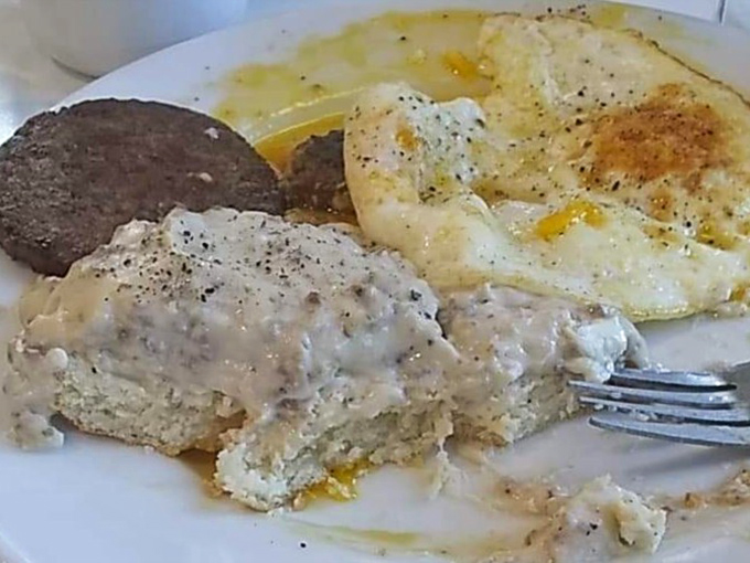 Breakfast nirvana achieved: fluffy biscuits swimming in creamy gravy alongside sunny eggs and sausage &ndash; the holy trinity of Southern morning comfort.
