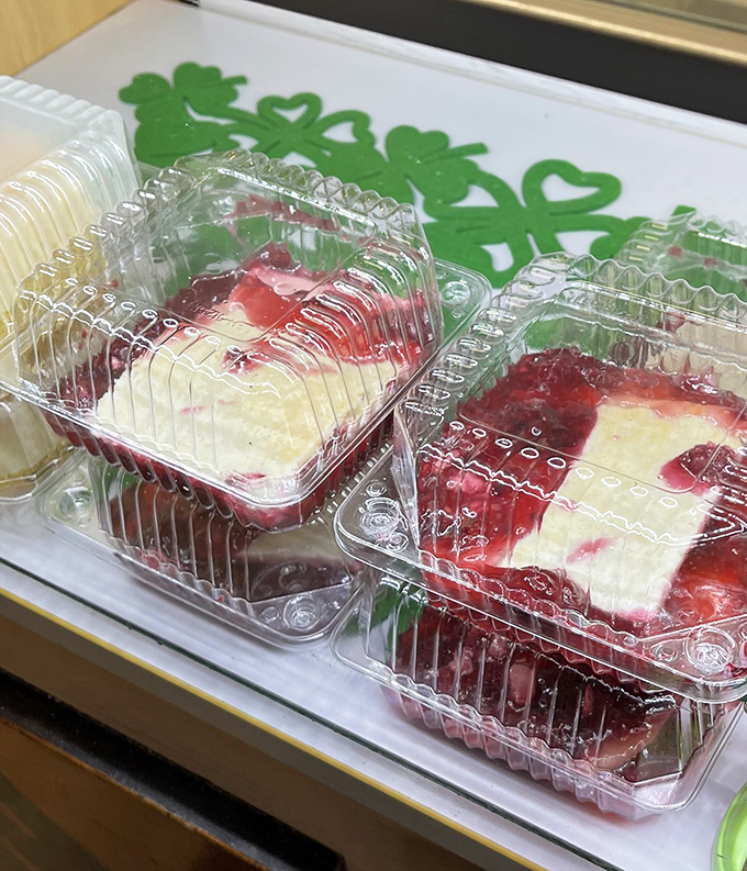 Dessert that demands a moment of silence. These berry-topped treasures aren't just served—they're presented as evidence that happiness can be contained in a plastic container.