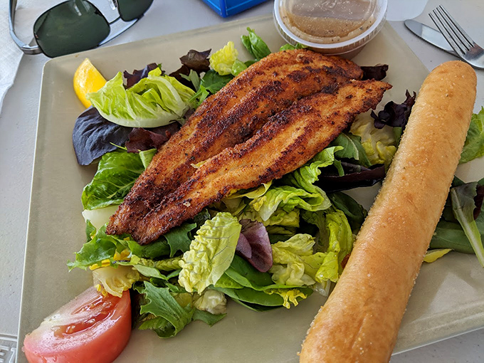 Blackened fish atop fresh greens with a breadstick standing guard. It's a salad that makes you forget you ordered a salad.