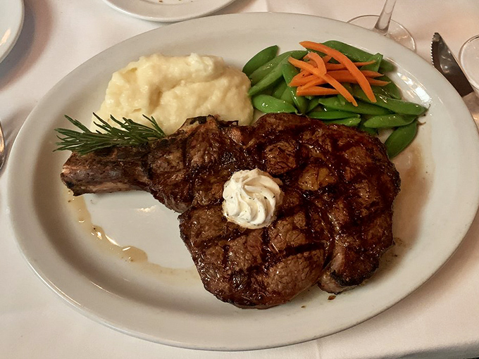 This bone-in ribeye isn't just dinner; it's a primal experience with a side of mashed potatoes so creamy they could make a grown person weep with joy.