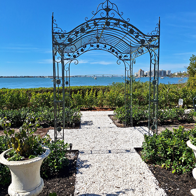 A wrought-iron archway frames the perfect view&mdash;nature's version of Instagram filters exists in Siesta Key's hidden gardens.