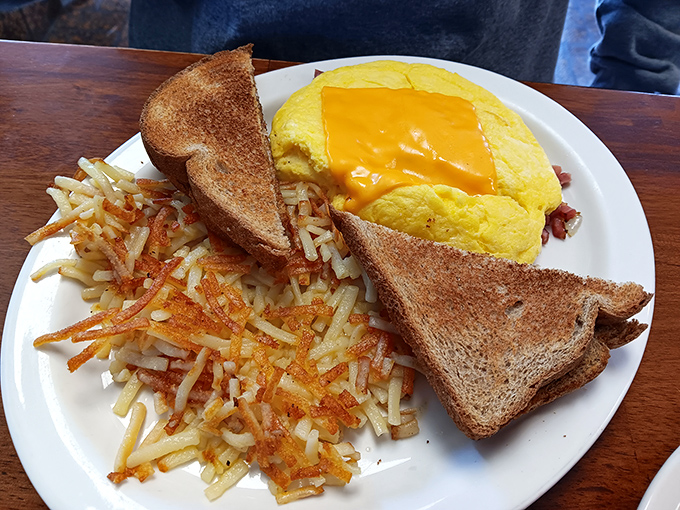 Simple perfection on a plate: golden hash browns with the ideal crisp-to-soft ratio, toast that actually got toasted, and an omelet wearing its cheese like a proud yellow badge.