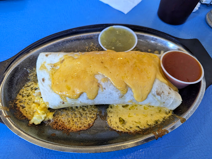 The breakfast burrito in its natural habitat &ndash; smothered in cheese and flanked by both red and green chile. Christmas comes daily in New Mexico.