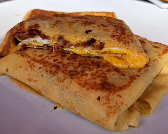 Breakfast crepes with melted cheese and perfectly cooked eggs – proof that sometimes the simplest combinations create the most memorable bites.