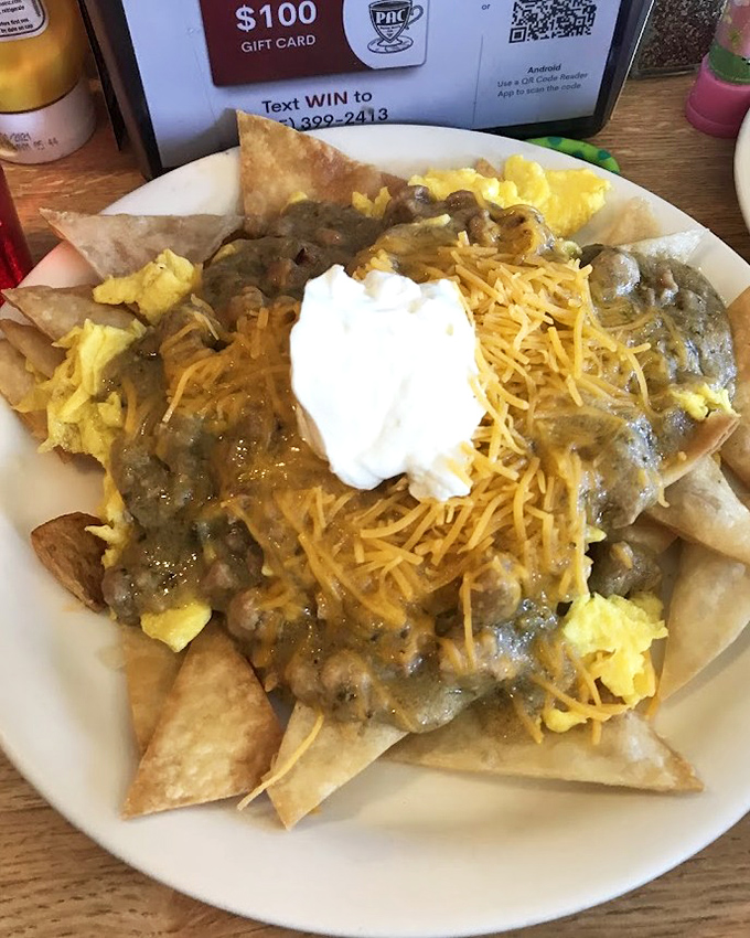 Breakfast nachos that laugh in the face of convention. Tortilla chips playing host to eggs, cheese, and green chile sauce—morning fiesta on a plate!