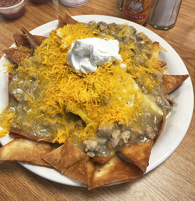 Breakfast nachos that laugh in the face of convention. When tortilla chips meet green chile, cheese, and sour cream, morning meetings can wait.