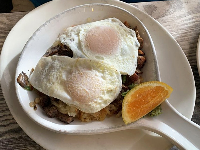 Breakfast skillets that could fuel a farmhand for days. Two sunny-side-up eggs crown this mountain of morning perfection.