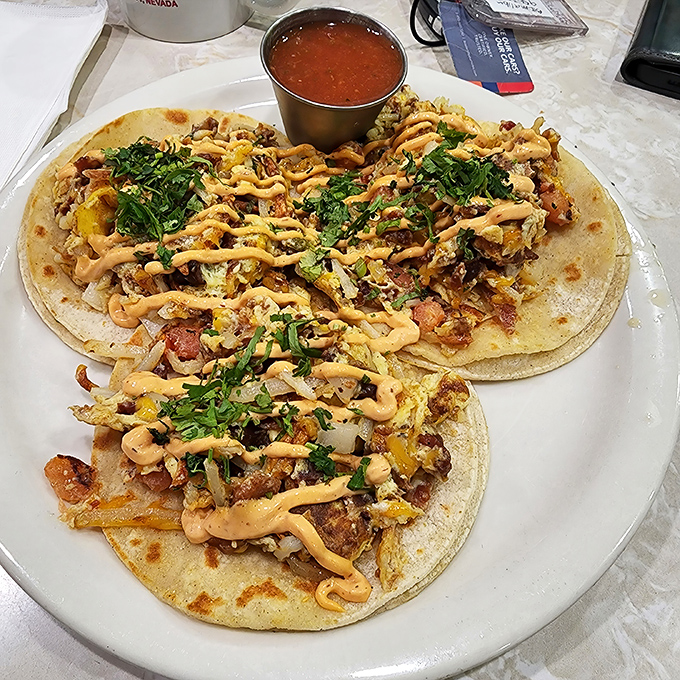 Breakfast tacos that don't mess around &ndash; loaded with scrambled eggs, topped with sauce, and garnished with enough cilantro to make your morning memorable.