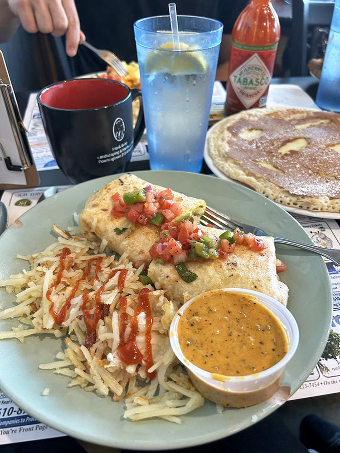 Breakfast burrito perfection with fresh pico de gallo and golden hash browns. That little cup of sauce isn't just condiment&mdash;it's liquid sunshine for your taste buds.
