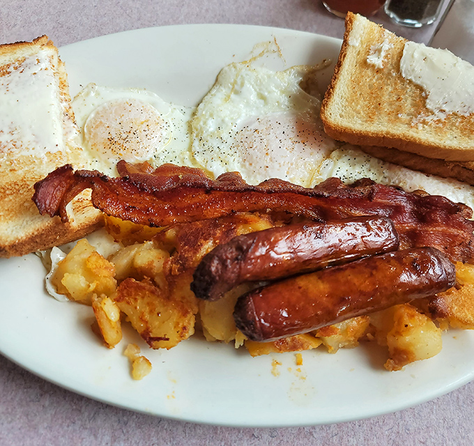 The breakfast trinity—eggs, bacon, and sausage—accompanied by home fries that somehow manage to be both crispy and tender. Breakfast nirvana achieved.