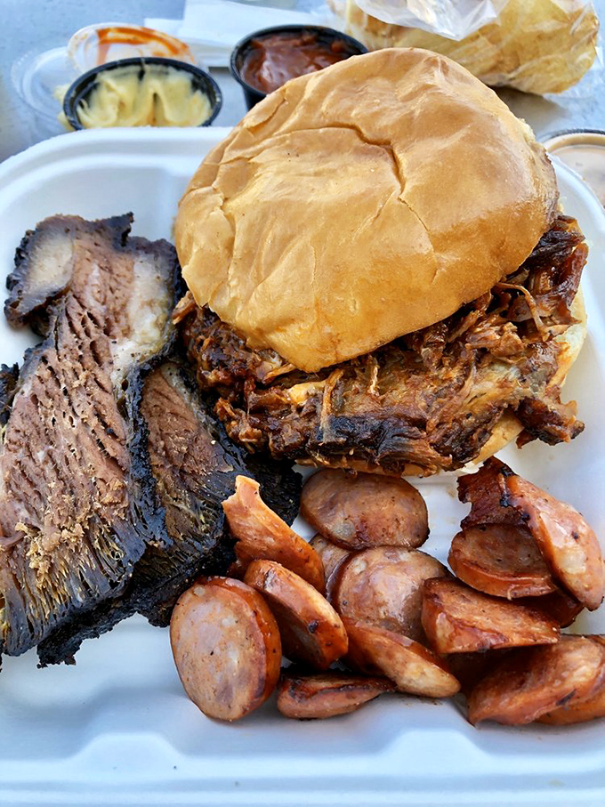 A BBQ trifecta: Perfectly sliced brisket with that coveted smoke ring, pulled pork sandwich, and sausage&mdash;the holy trinity of smokehouse heaven.