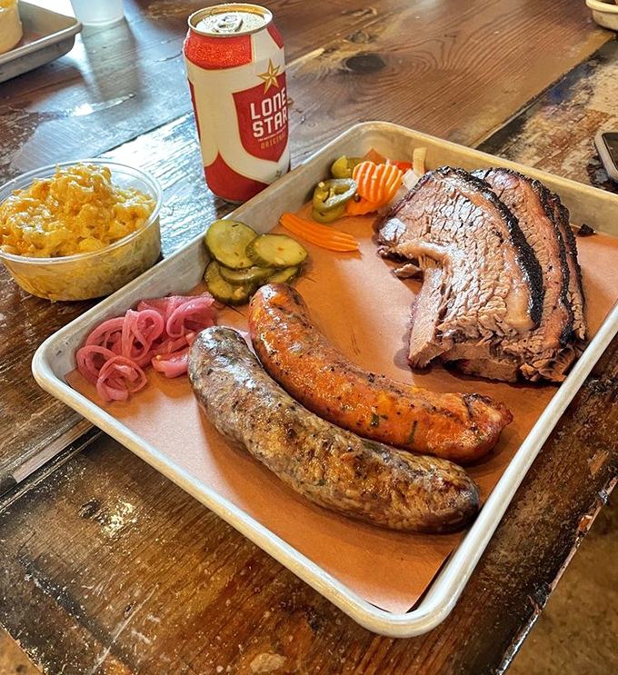 A Texas trinity on display: perfectly smoked brisket, sausage with a snap that echoes across the room, and pickled accoutrements to cut through the richness.