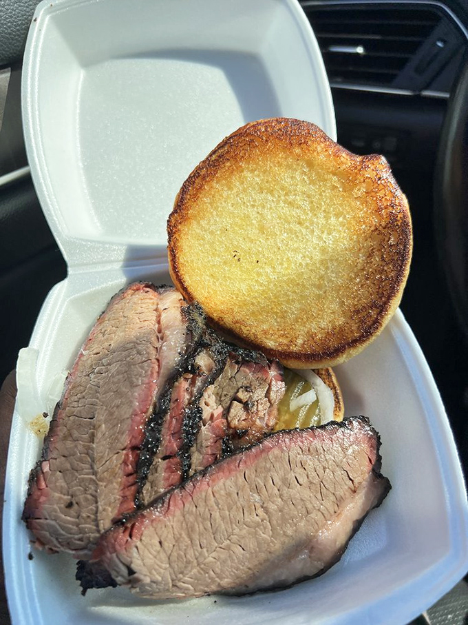 Brisket slices with that telltale pink smoke ring nestled in a takeout container &ndash; proof that sometimes the best things come in humble packages.