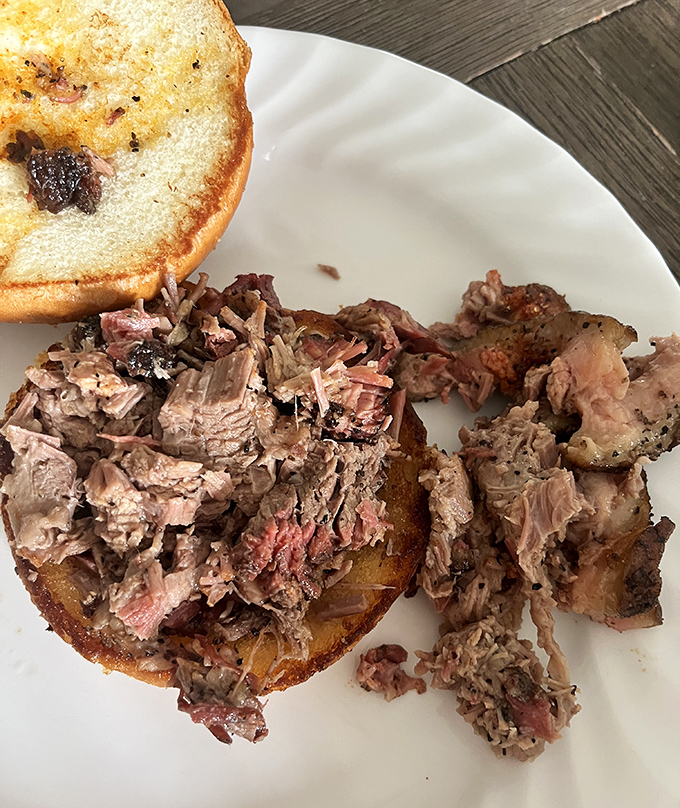 This isn't just a sandwich; it's architectural genius – pulled meat piled high on a toasted bun, ready for its close-up before disappearing forever.