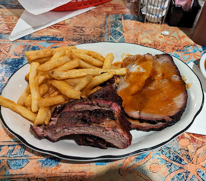 This isn't just food, it's edible art &ndash; perfectly smoked brisket and ribs sharing a plate with golden fries, a composition that belongs in the Museum of Delicious Things.