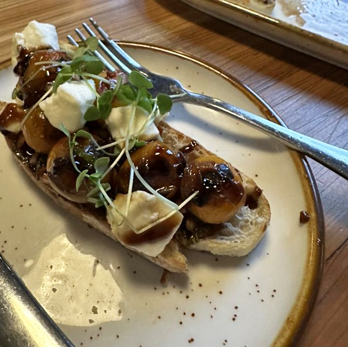Not just bruschetta&mdash;a canvas of crusty bread topped with balsamic-kissed mushrooms, creamy cheese, and microgreens that elevate this appetizer to art form.