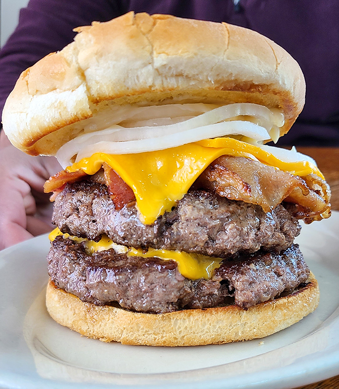 Behold the burger that launched a thousand road trips. Two hefty patties, melted cheese, and the kind of construction that requires both hands and a strategy.