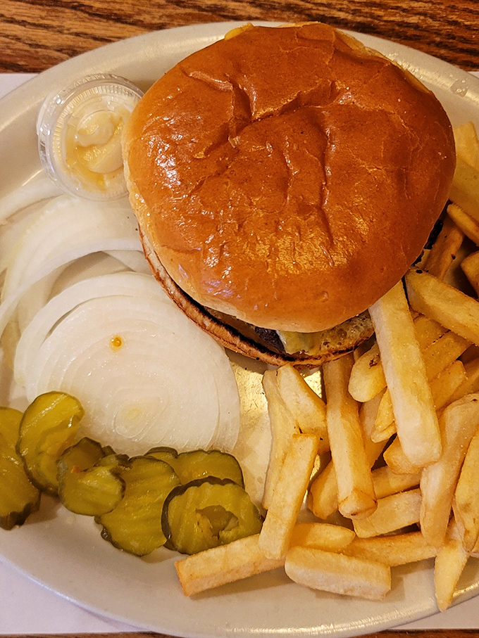 A burger that demands a two-handed commitment, served with the kind of fries that make you forget counting calories was ever invented.