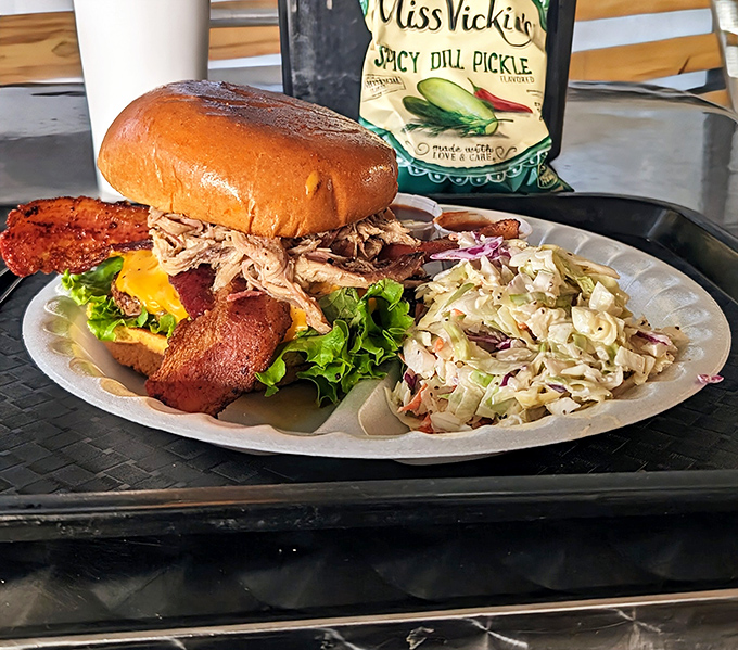 This isn't just a sandwich; it's an architectural marvel of pulled pork, bacon, and fresh veggies on a golden throne.