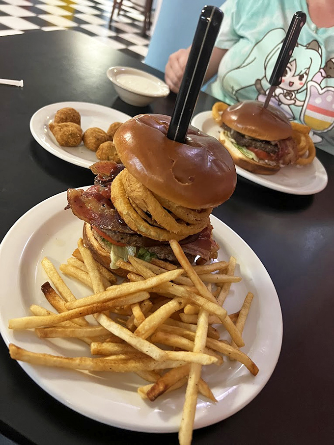 Not so much a burger as a gravity-defying monument to American excess, complete with a knife speared through its heart for dramatic effect.