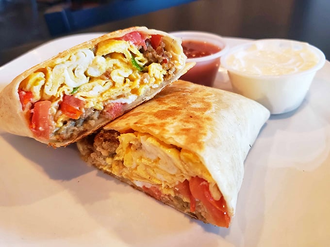 This breakfast burrito has been cut open to reveal its secrets – a treasure chest of eggs, meat, and veggies.