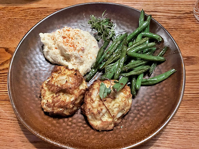 Golden-brown crab cakes that are mostly crab and barely cake, served with a side of green beans that actually taste like vegetables should.
