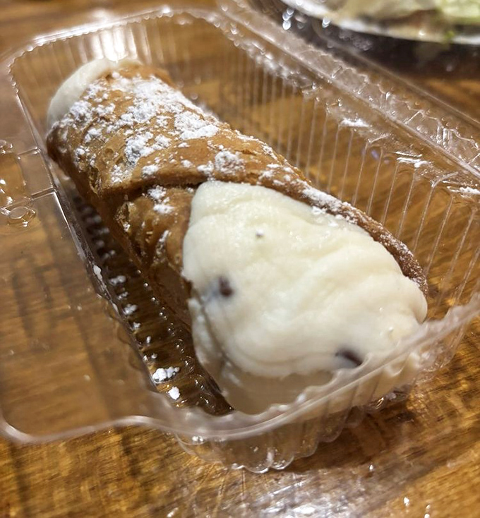 A cannoli that's dressed for success with powdered sugar and creamy filling. The crunch-to-cream ratio here is what mathematicians call "the golden ratio of desserts."