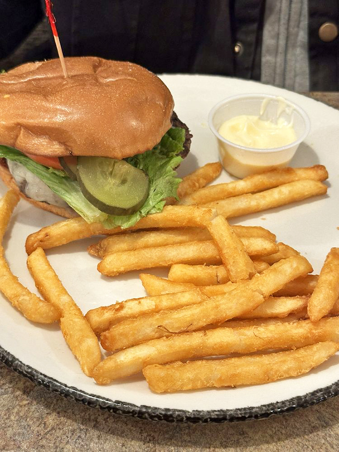 A perfectly grilled burger with golden fries proves that lunch here is just as serious as breakfast.