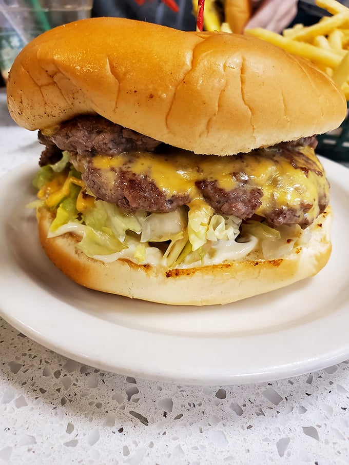 This isn't just a burger; it's an architectural masterpiece of beef, cheese, and veggies that requires both hands and zero shame.